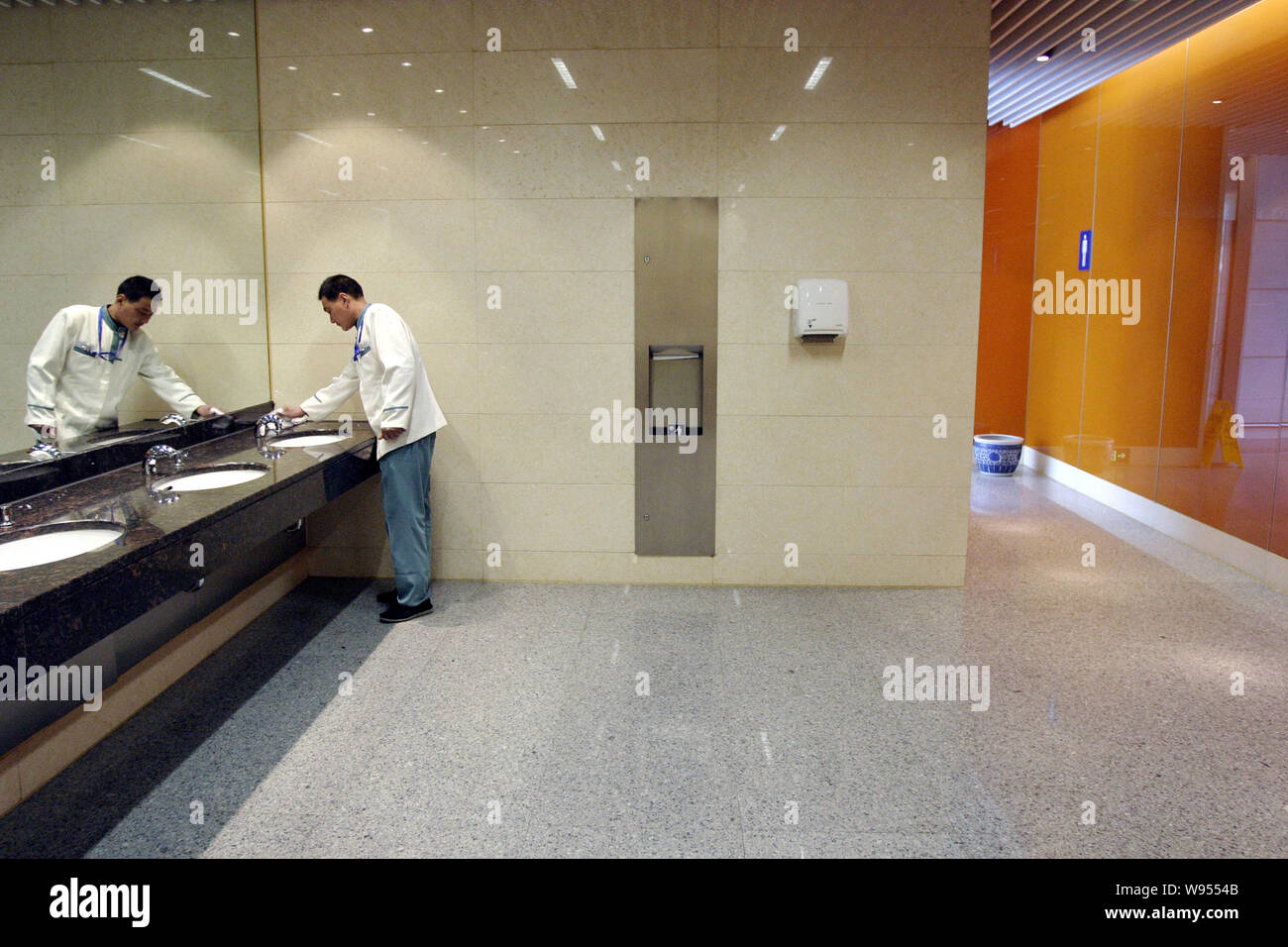 --FILE--A Chinese worker is cleaning a public toilet in the Terminal 3 ...