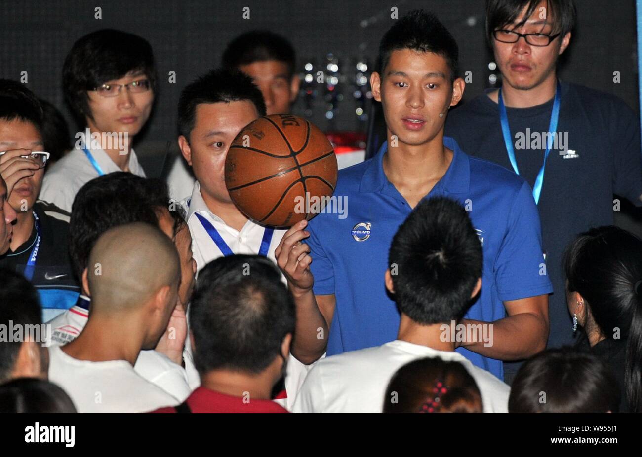NBA basketball star Jeremy Lin (C in blue) takes a basketball at a TV ...