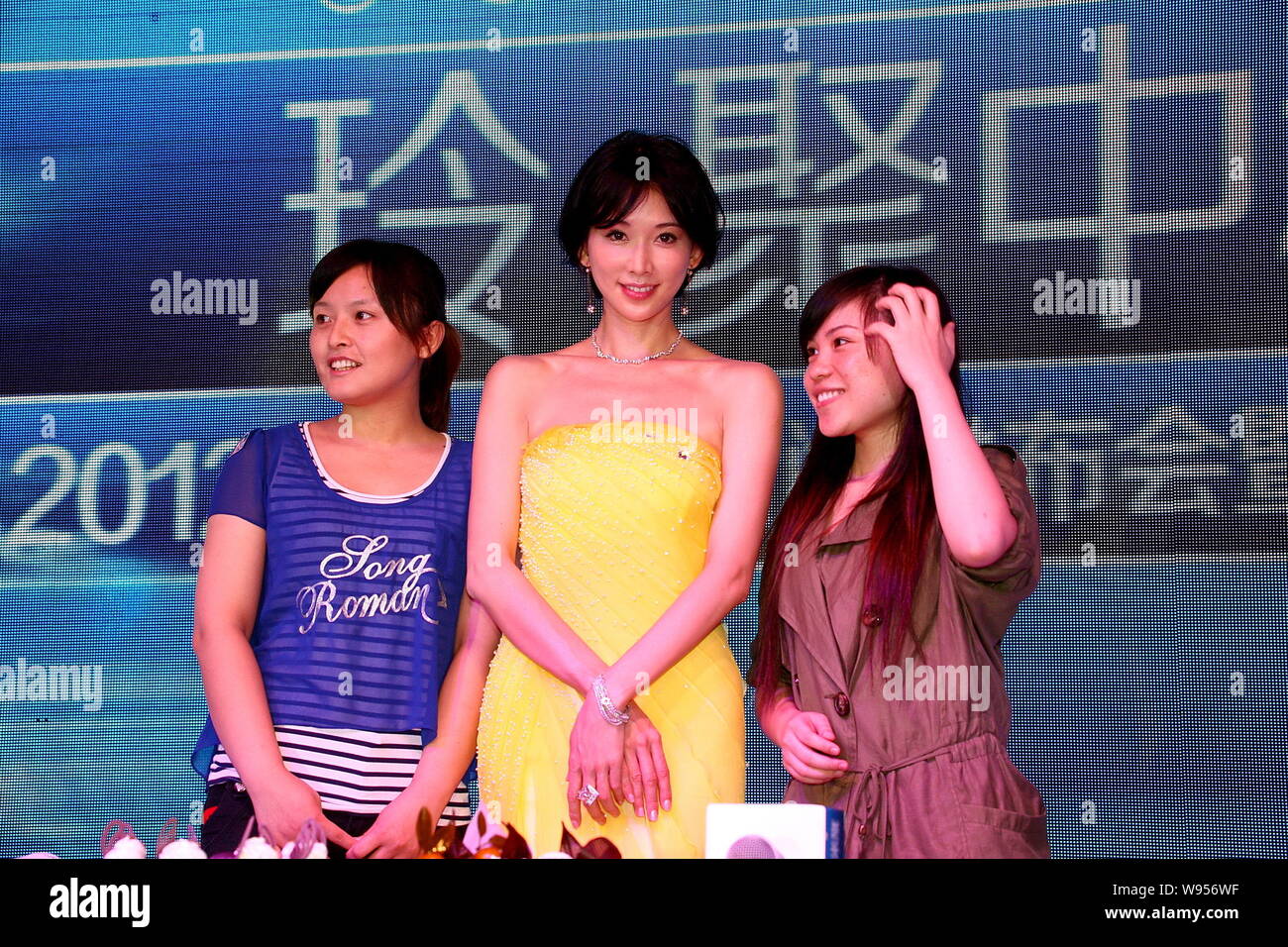 Taiwanese model and actress Lin Chi-ling (yellow) poses with fans ...