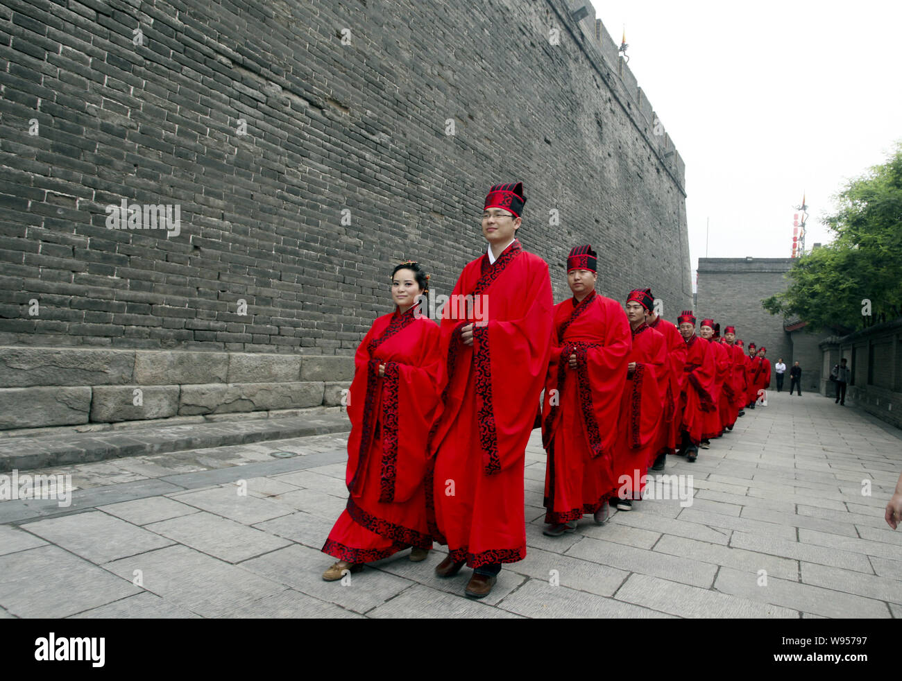 Couples of newlyweds dressed in traditional Han costumes take part in a ...