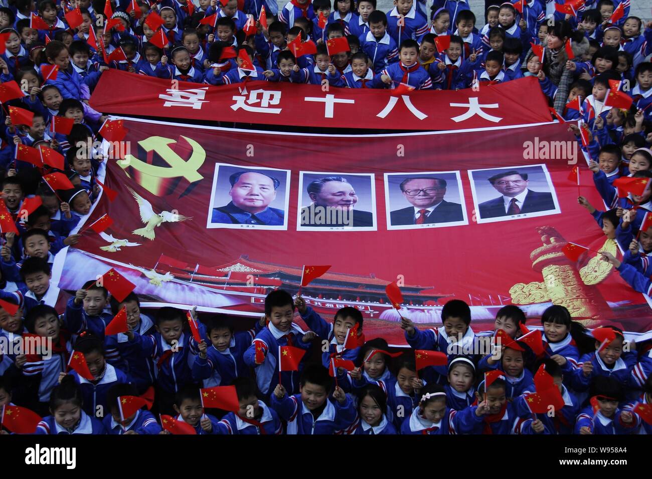 Young Chinese students wave national flags and unfurl a banner with ...