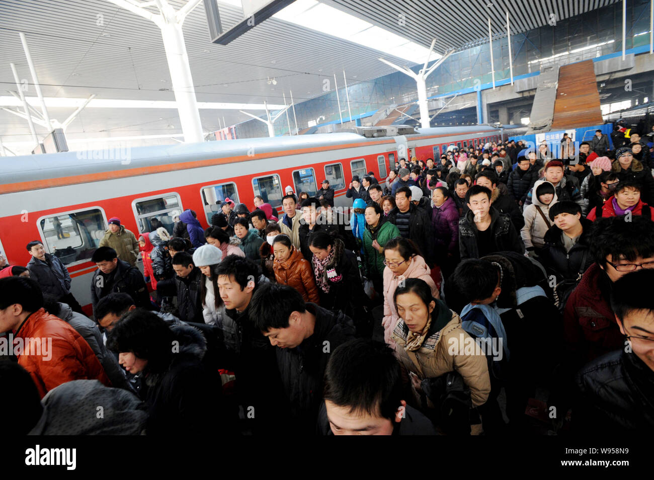 A crowd of Chinese passengers walk on the platform at the Shenyang ...