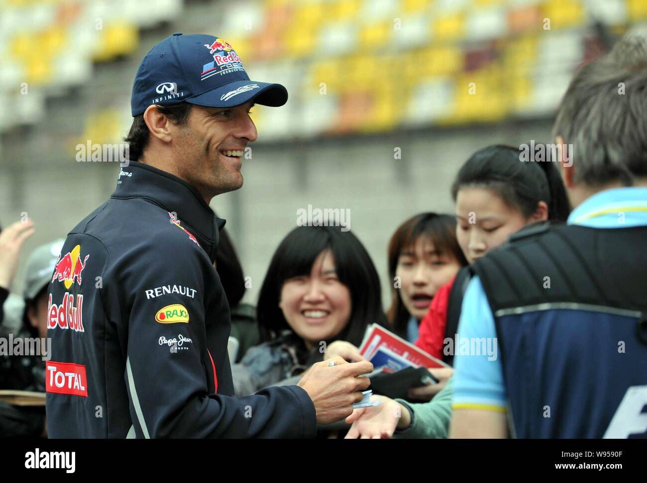 Australian F1 driver Mark Webber of the Red Bull team signs for fans ...