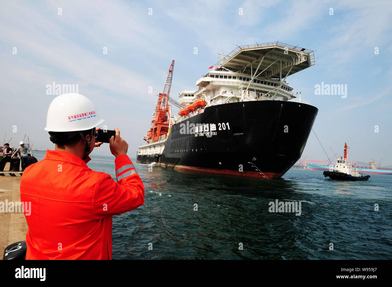 A Chinese worker takes pictures of the newly-built deepwater pipelaying ...