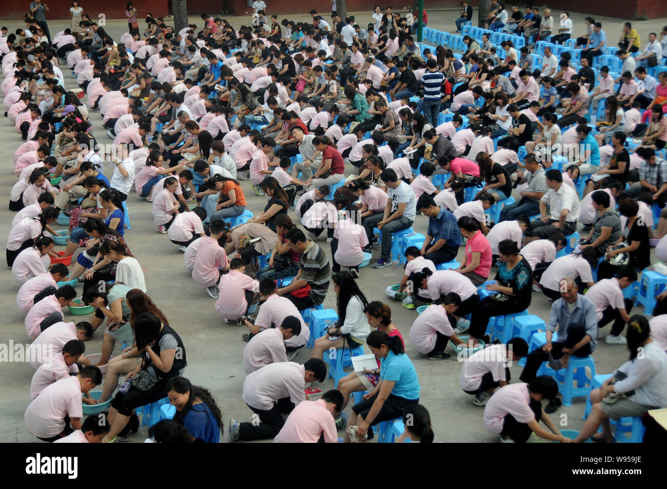 Young Chinese students wash feet of their parents on the playground at ...