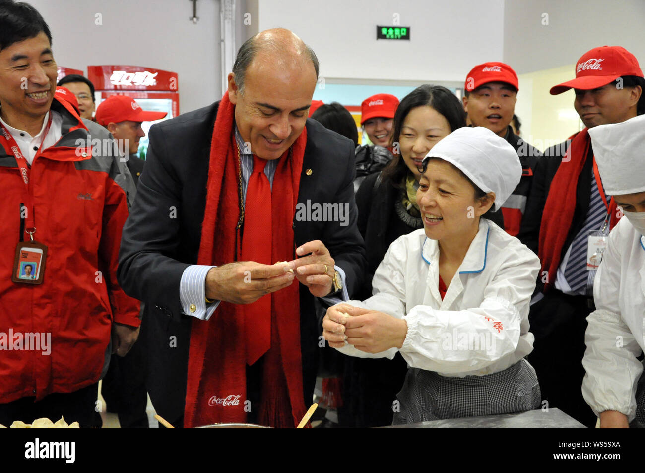 Muhtar Kent, center, Chairman and CEO of The Coca-Cola Company, learns ...