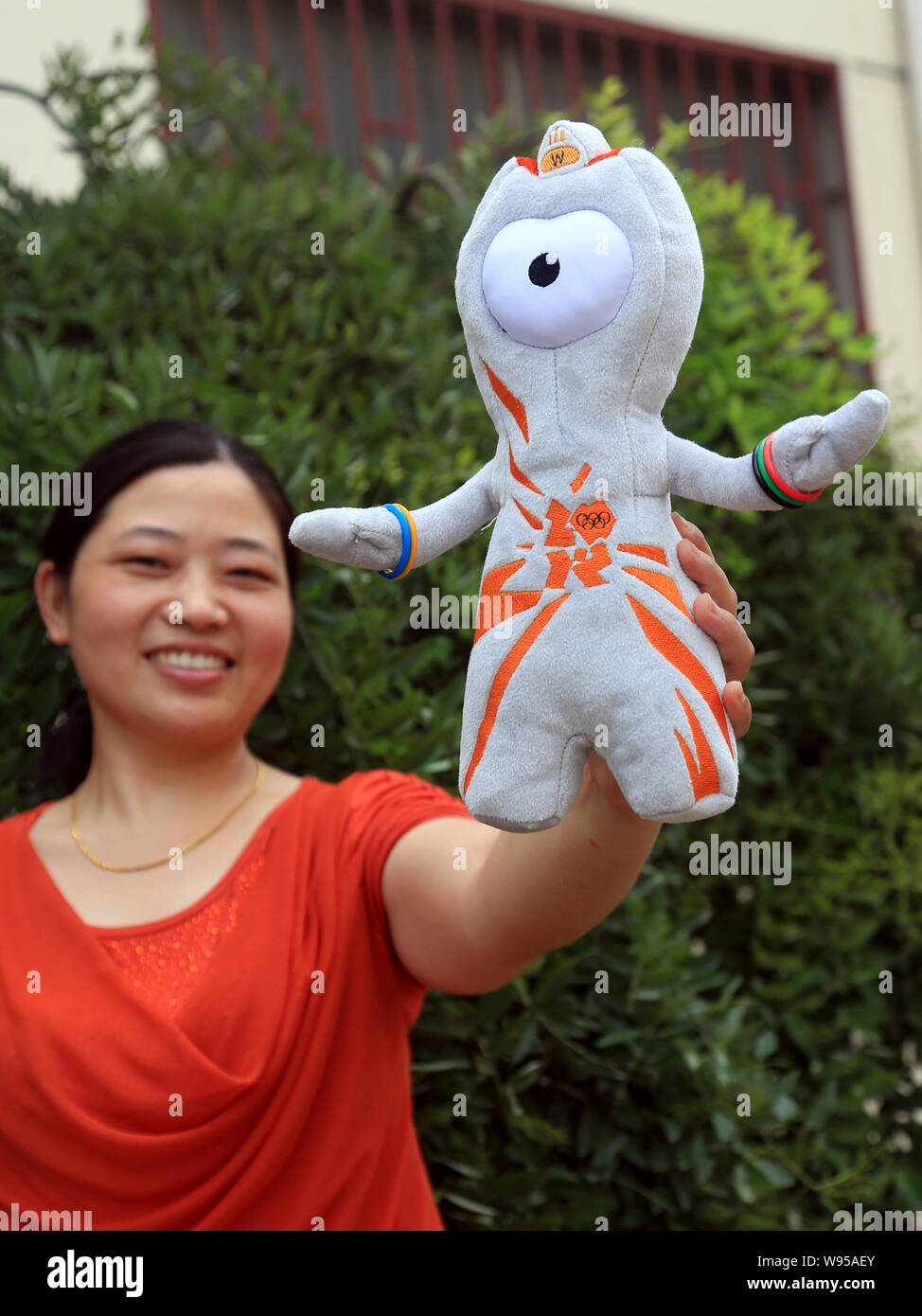 A Chinese worker shows a toy of Wenlock, the mascot of the London 2012 ...