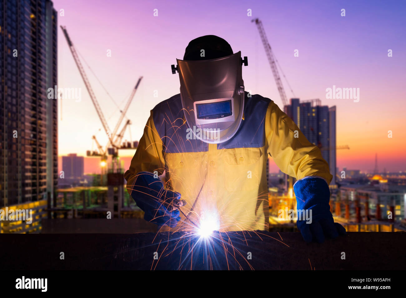 Industrial worker welding steel structure for infrastructure building ...