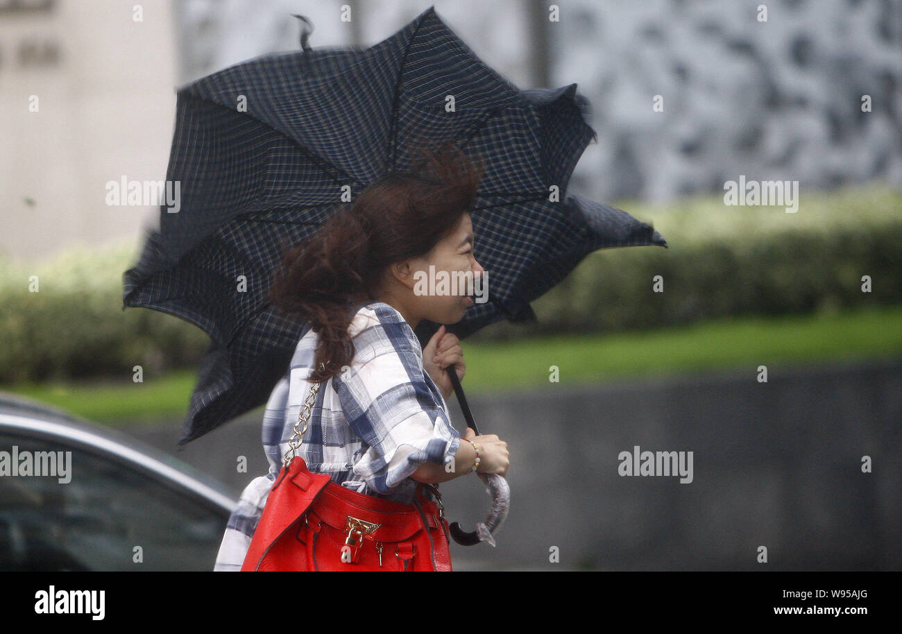 A pedestrian braves strong wind and heavy rain caused by Typhoon Haikui ...