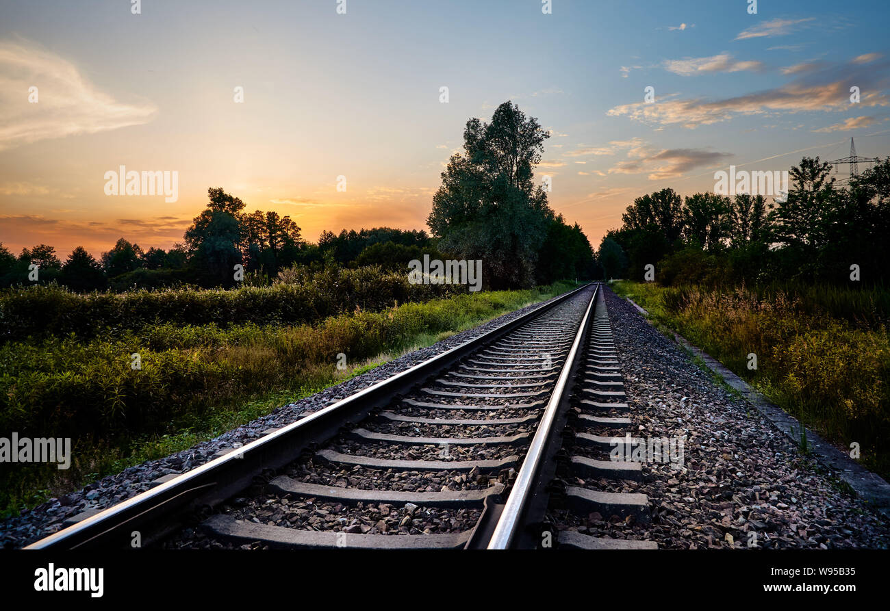 Railroad track in rural landscape at sunset in Rastatt, Germany Stock ...