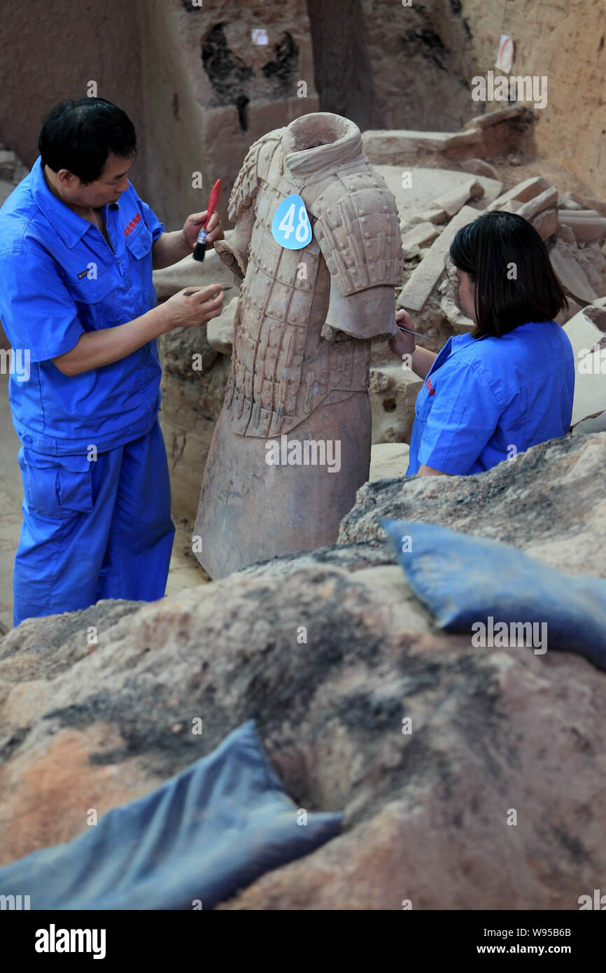 Chinese archaeologists work on a terracotta warrior in the No.1 Pit at ...