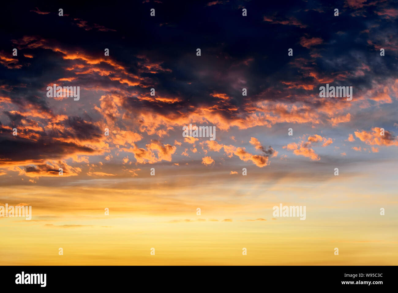 Dark thunderclouds with red orange reflections of the setting sun ...