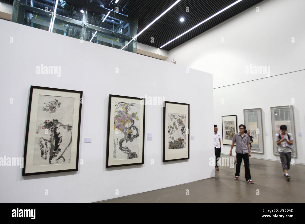 Visitors walk past paintings at the China Art Museum in the China ...