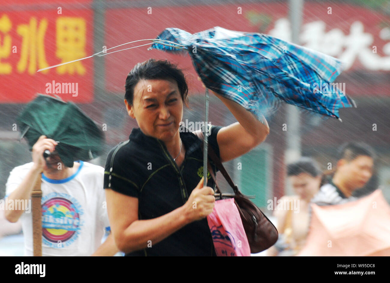 Pedestrians brave strong wind and heavy rain caused by Typhoon Haikui ...