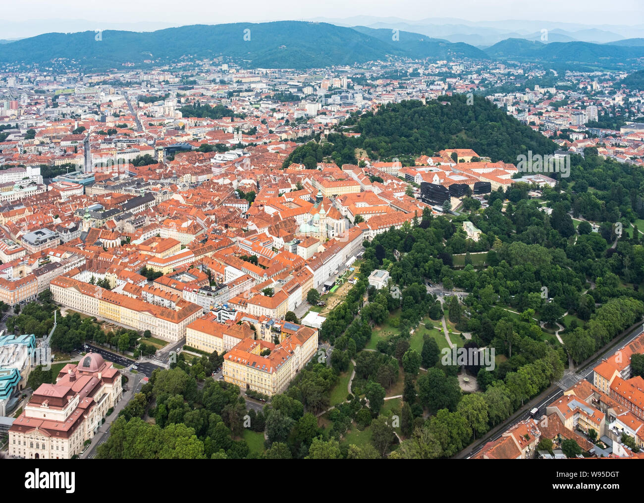 Aerial view of center city Graz from helicopter drone with hill ...