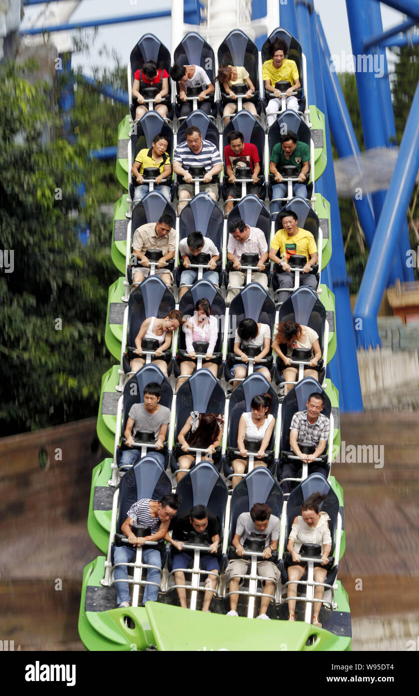 Tourists ride the Bullet Coaster at the Happy Valley in Shenzhen city ...