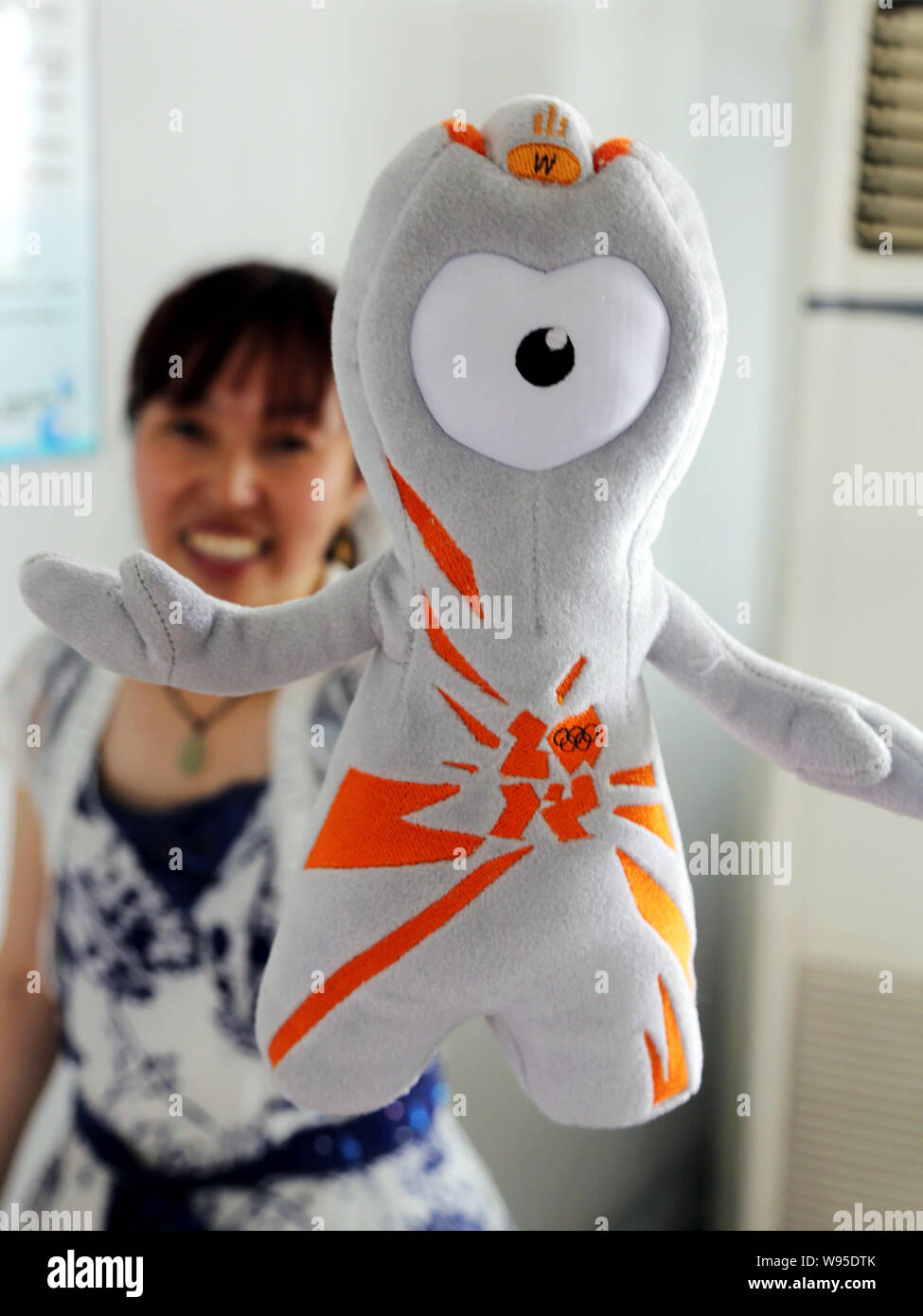 A Chinese worker shows a toy of Wenlock, the mascot of the London 2012 ...