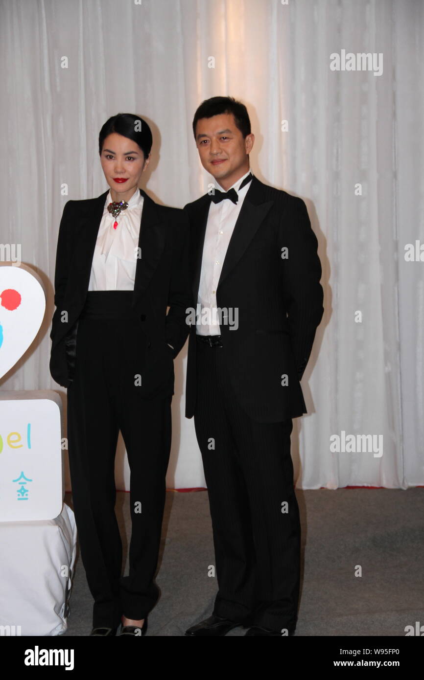 Hong Kong singer Faye Wong and her husband, Chinese actor Li Yapeng pose during a charity event ...