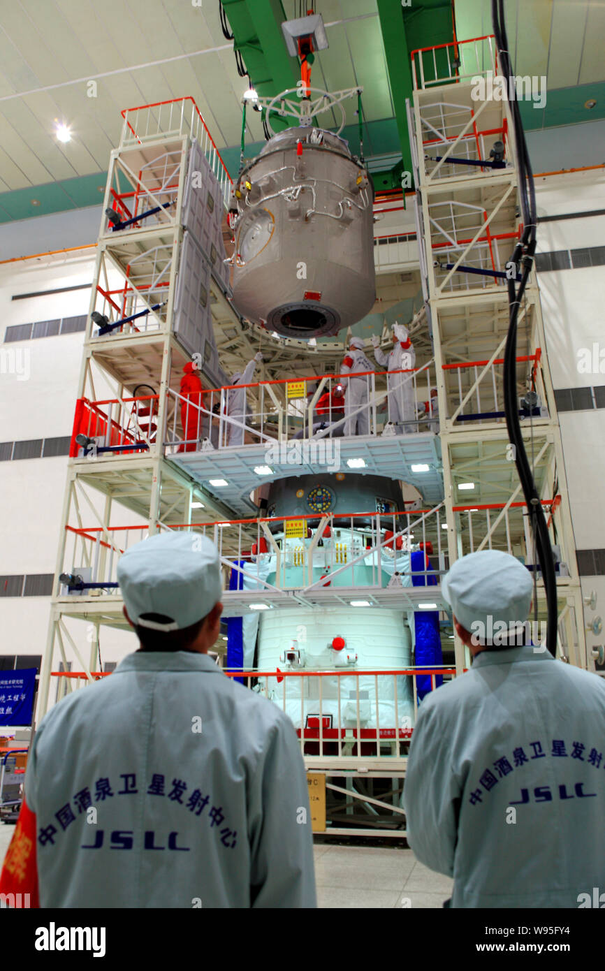 Chinese aerospace engineers connect the orbital module, top, with the ...