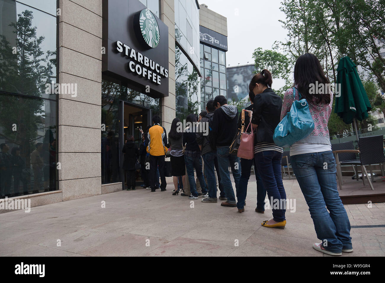 Customers line up to buy coffee at the first Starbuck Coffee cafe in ...