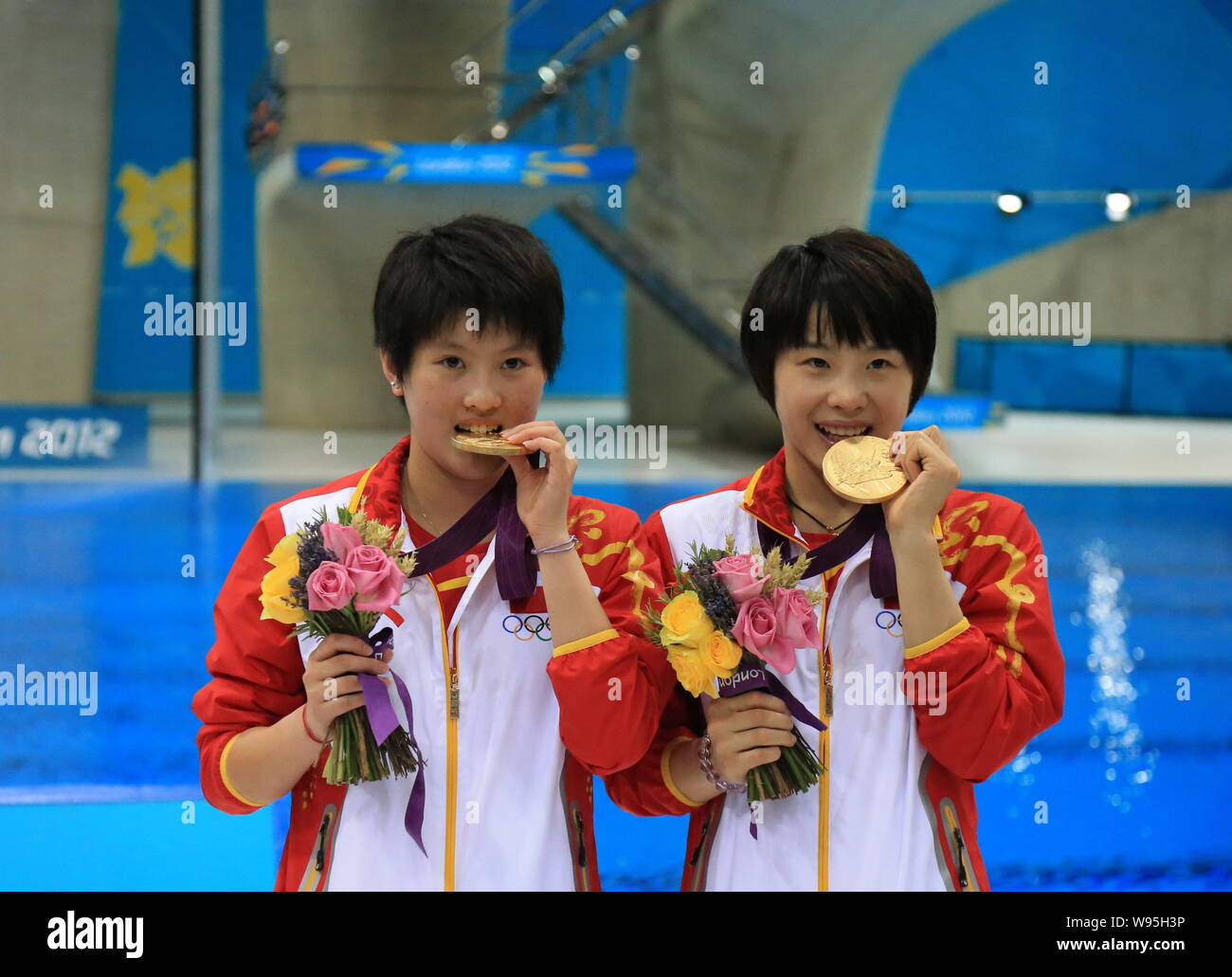 Gold medalists Chen Ruolin, left, and Wang Hao of China bite their ...