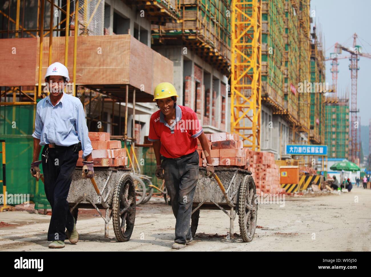 --FILE--Chinese migrant workers pull carts of bricks at the ...