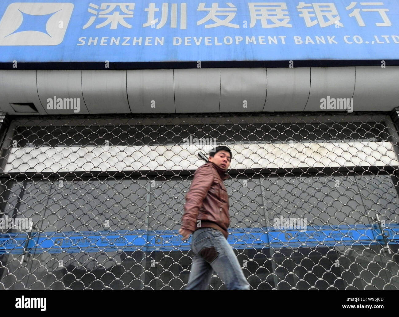 A pedestrian walks past a branch of Shenzhen Development Bank in ...