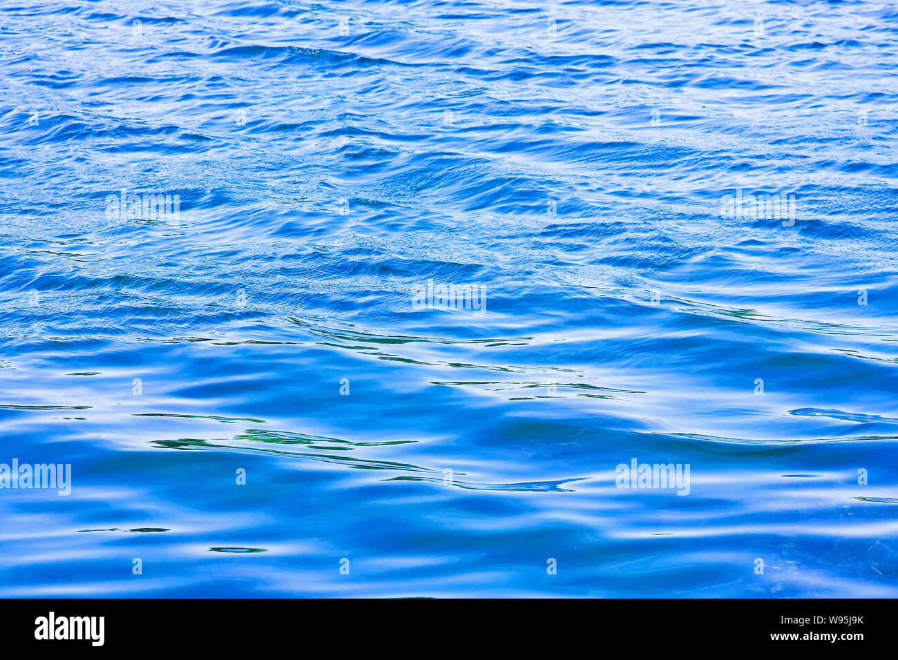 Blue and clean water surface with few ripples Stock Photo - Alamy