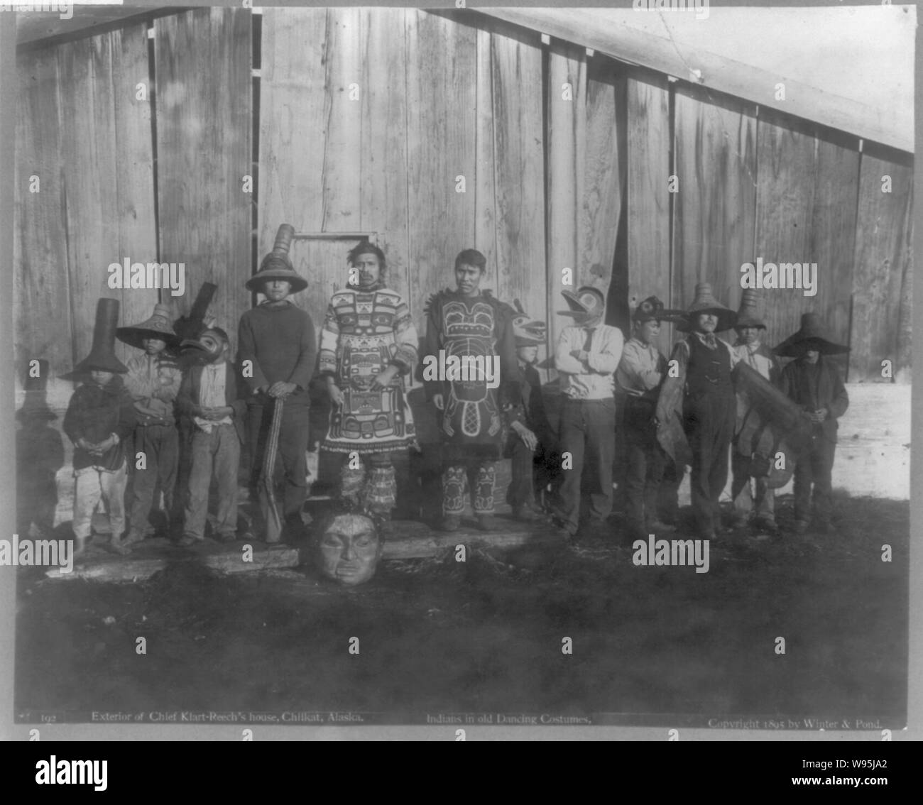 Alaskan Indians in old dancing costumes: group of 12 in front of Chief ...