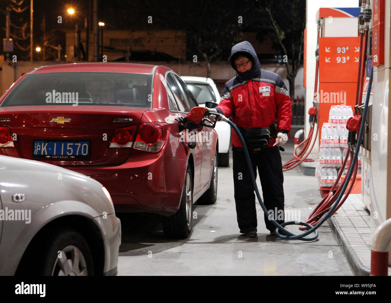 A Chinese worker refuels a car at a gas station in Shanghai, China, 7 ...