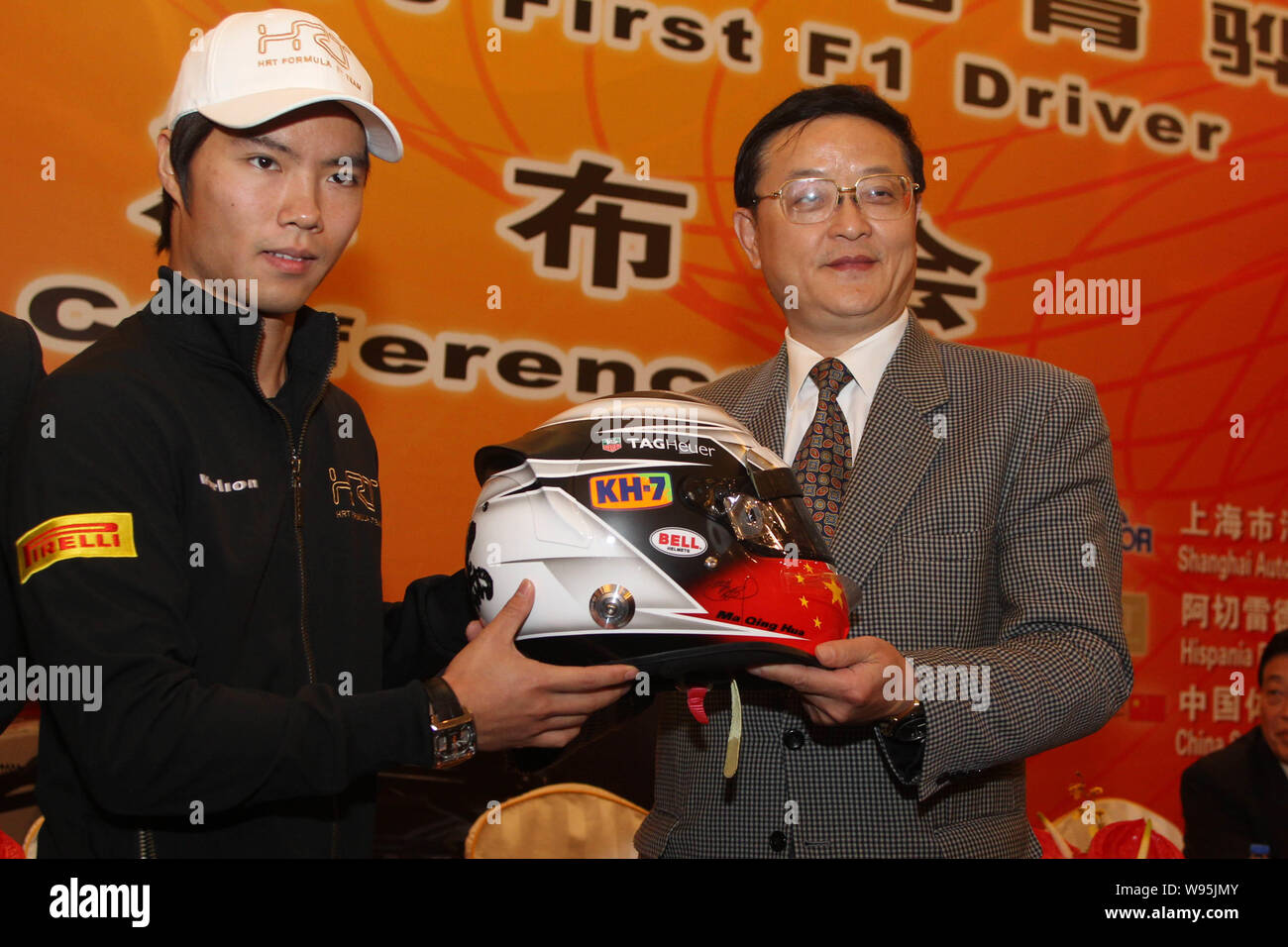Chinese F1 driver Ma Qinghua, left, shows his helmet with Li Yuyi ...