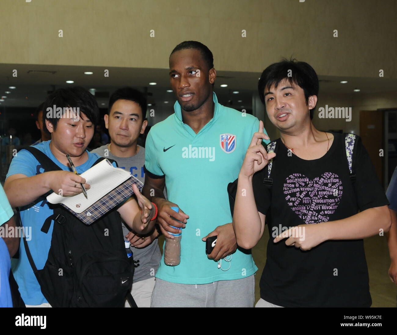 Didier Drogba of Shanghai Shenhua, second right, is followed by Chinese ...