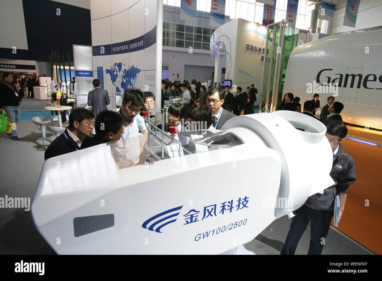 --File--Chinese visitors look at a model wind turbine on the booth of ...