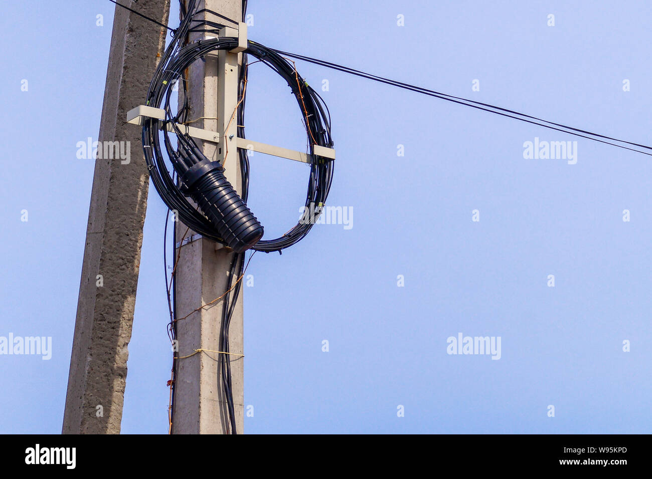 An internet or electric cable, rolled up into a ring, hangs on a pole ...