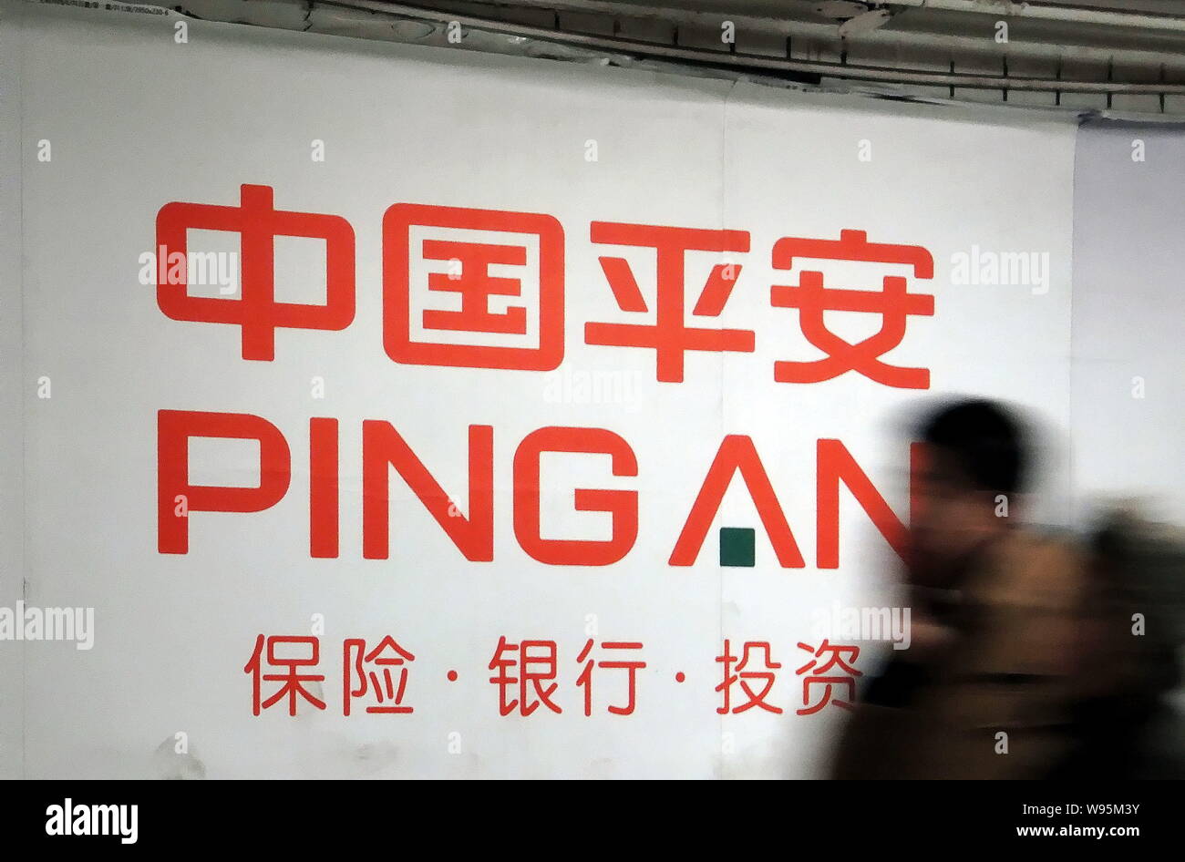 --FILE--Pedestrians walk past an advertisement for Ping An of China in ...