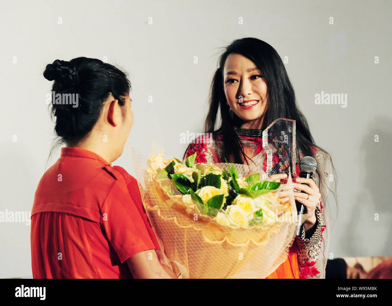 Chinese folk singer Sa Dingding (R) recieves flowers from a fan during ...