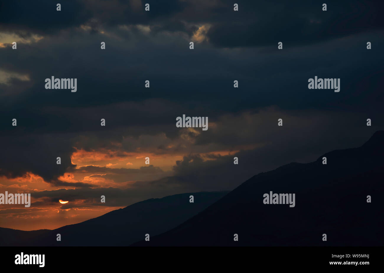Landscape in the mountains with sunrise in overcast sky Stock Photo - Alamy