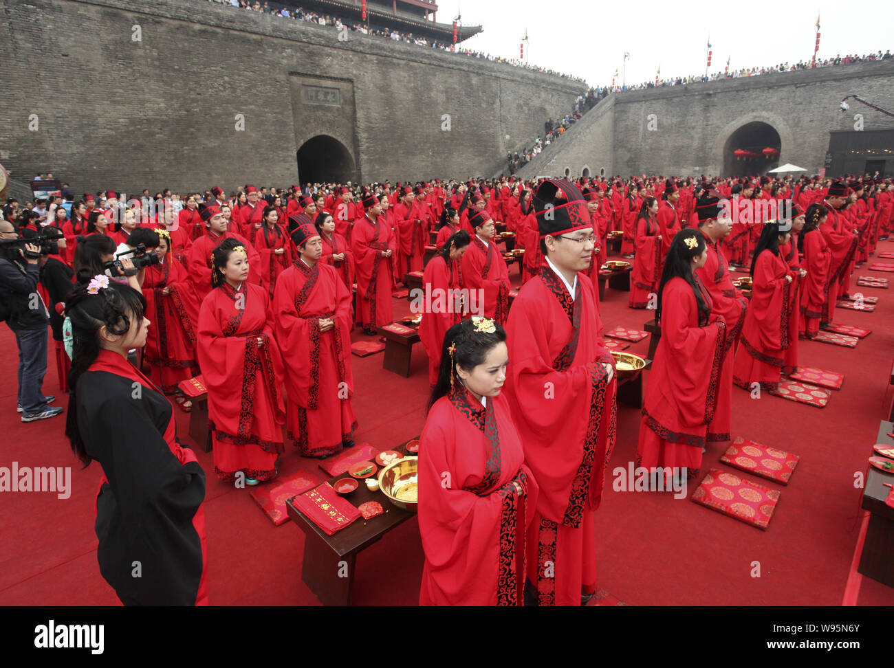 Couples of newlyweds dressed in traditional Han costumes pose during a ...