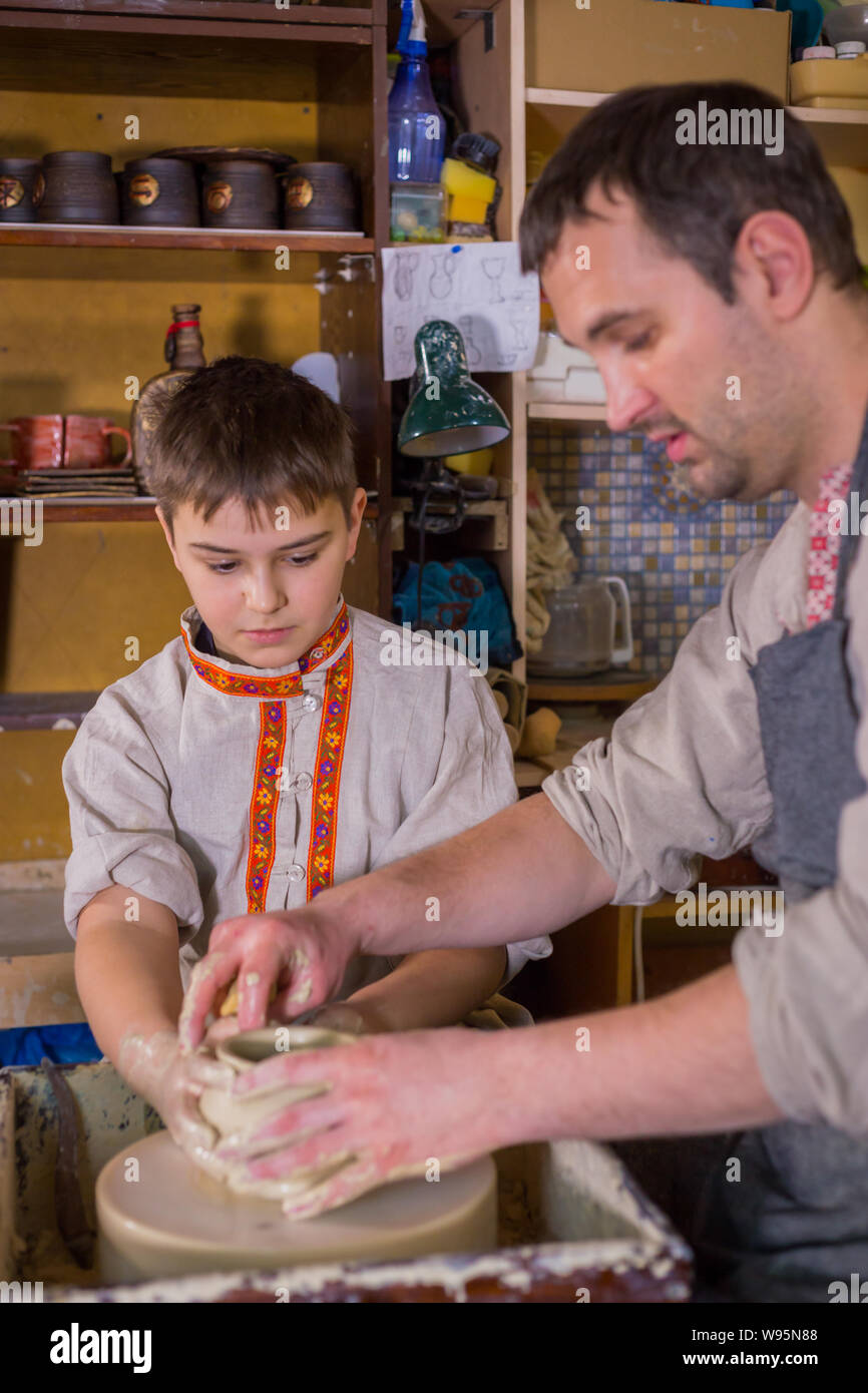Potter showing how to work with ceramic in pottery studio Stock Photo ...