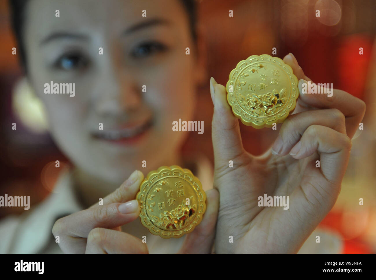 --FILE--A Chinese staff member shows gold mooncakes for the Mid-Autumn ...