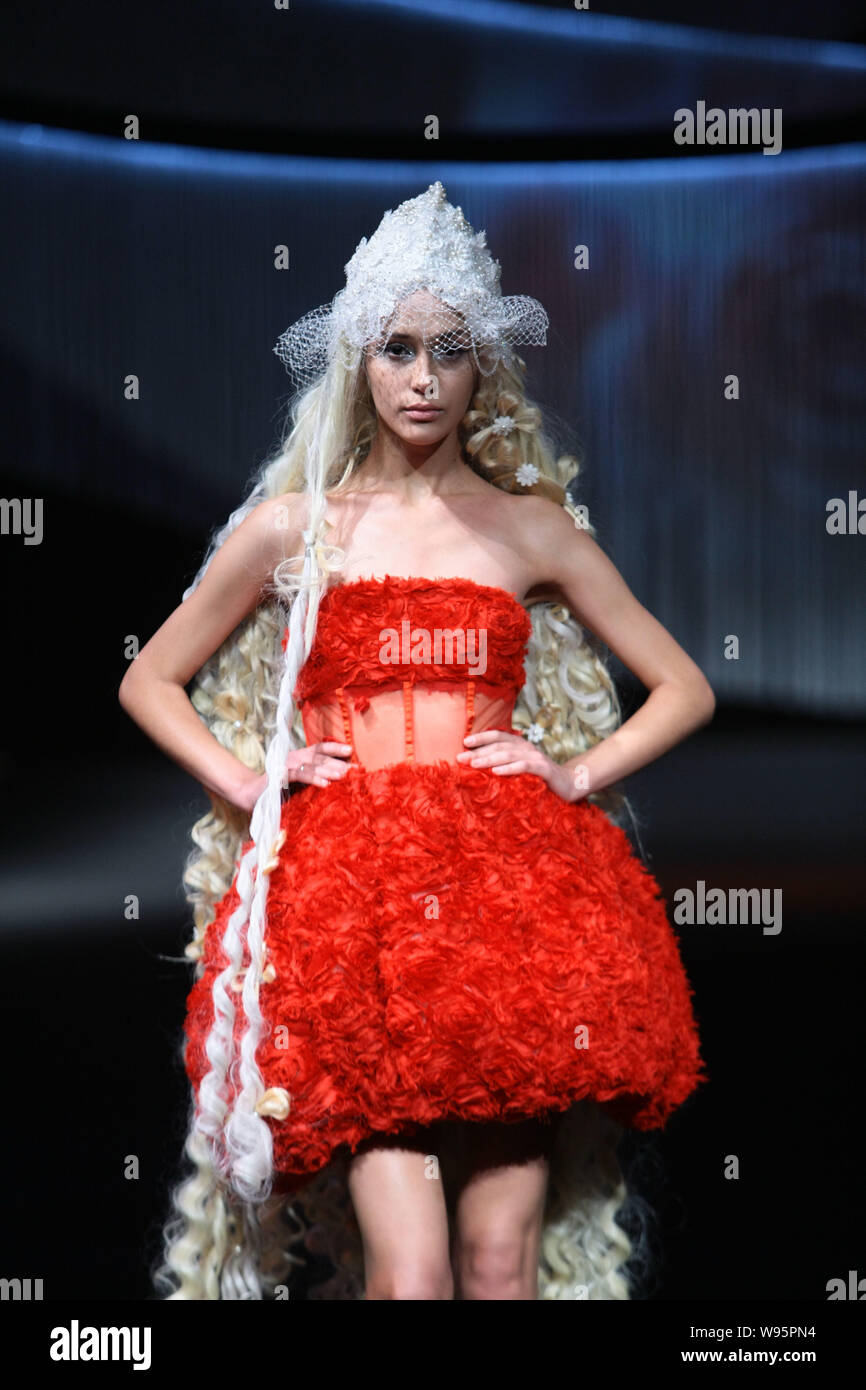 A model presents a new creation during the Rebecca 2013 wig trends ...