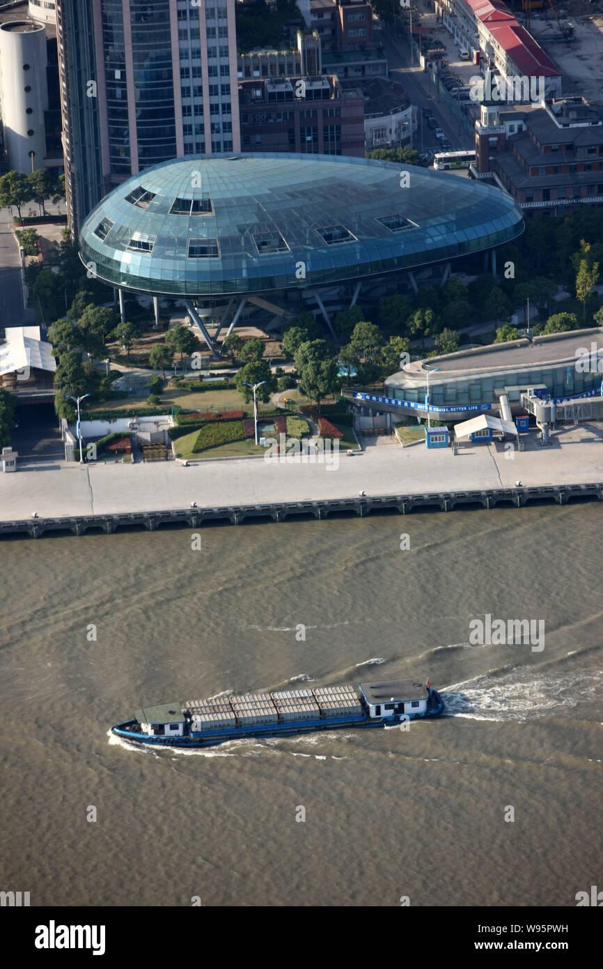 A cargo boat passes by the Shanghai Port International Cruise Terminal ...