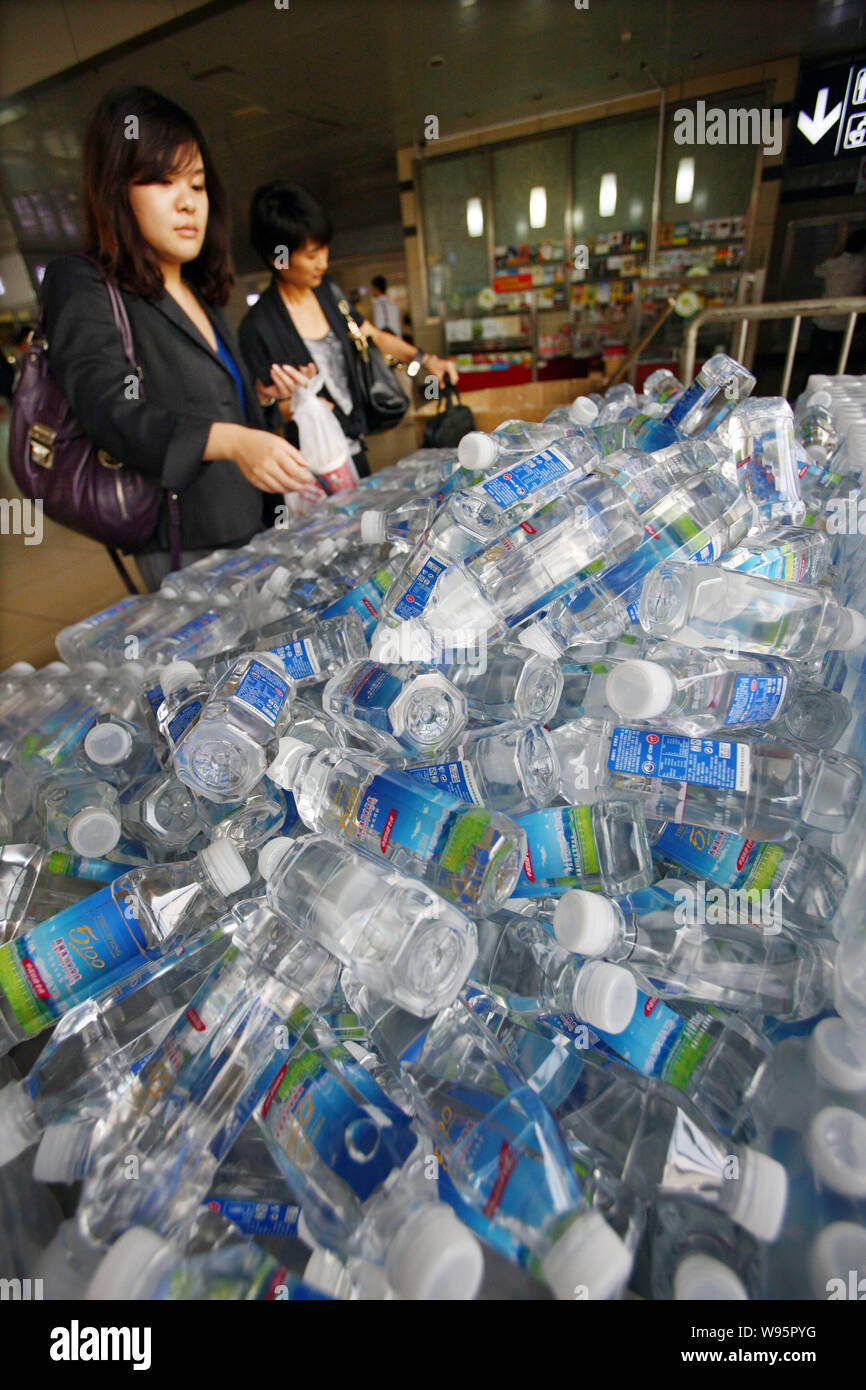 Chinese passengers take bottles of Tibet 5100 mineral water at the ...