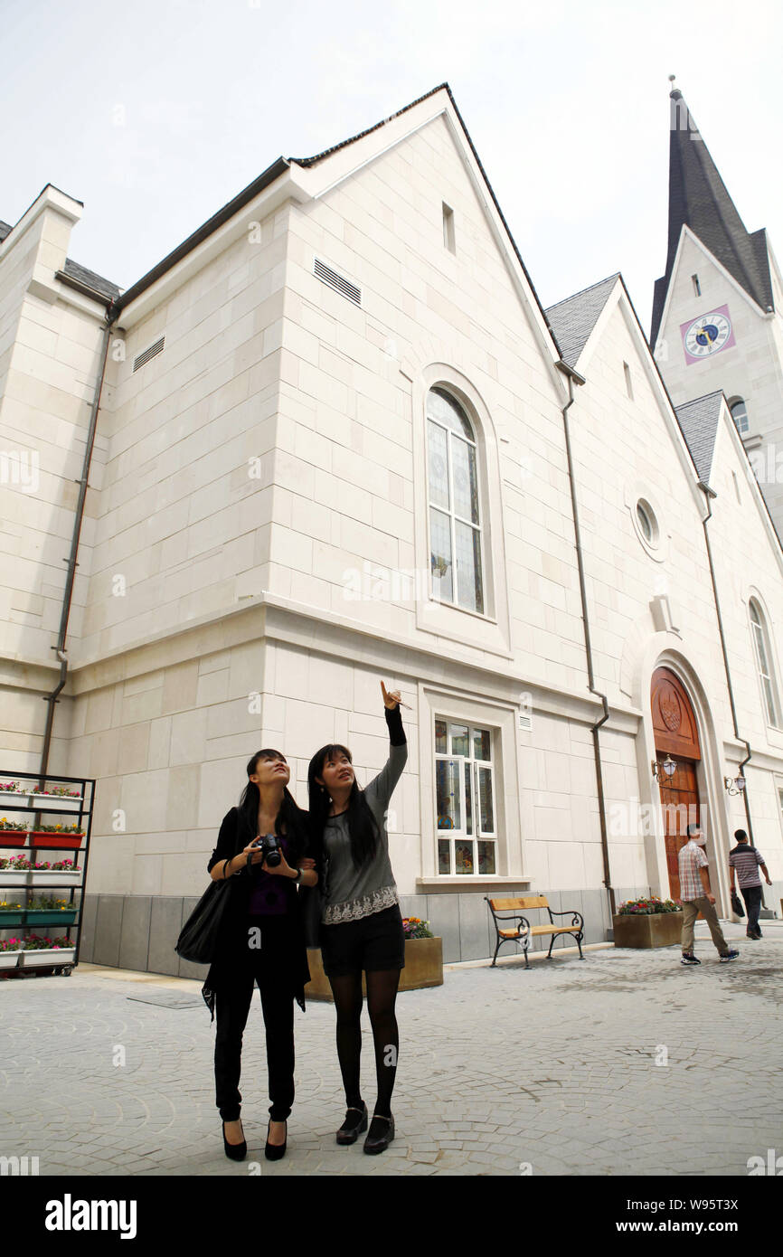 Tourists look at European-style houses in Hallstatt See, a replica of ...