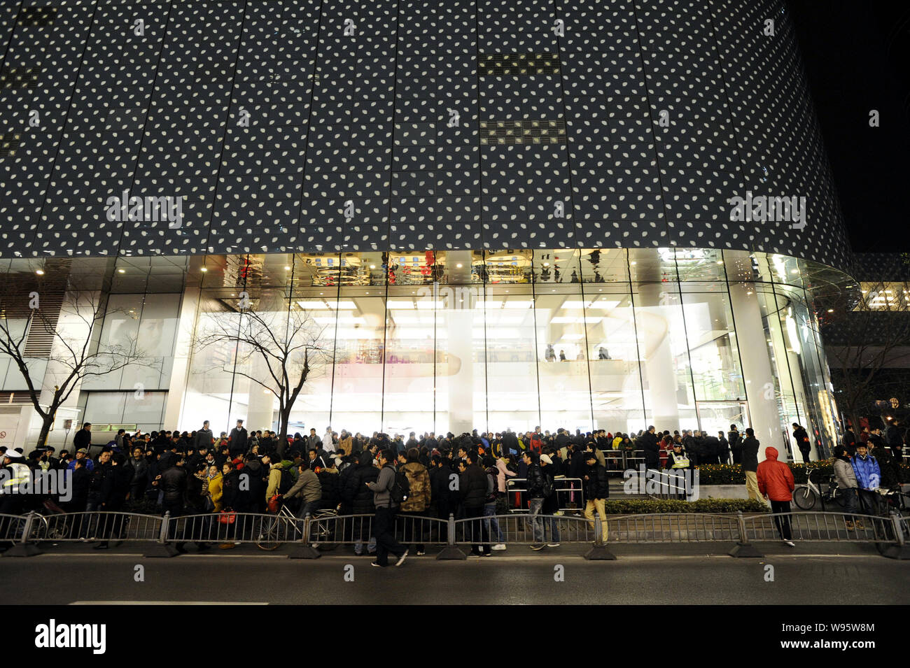 A crowd of buyers line up outside the Apple Store to purchase iPhone 4S ...