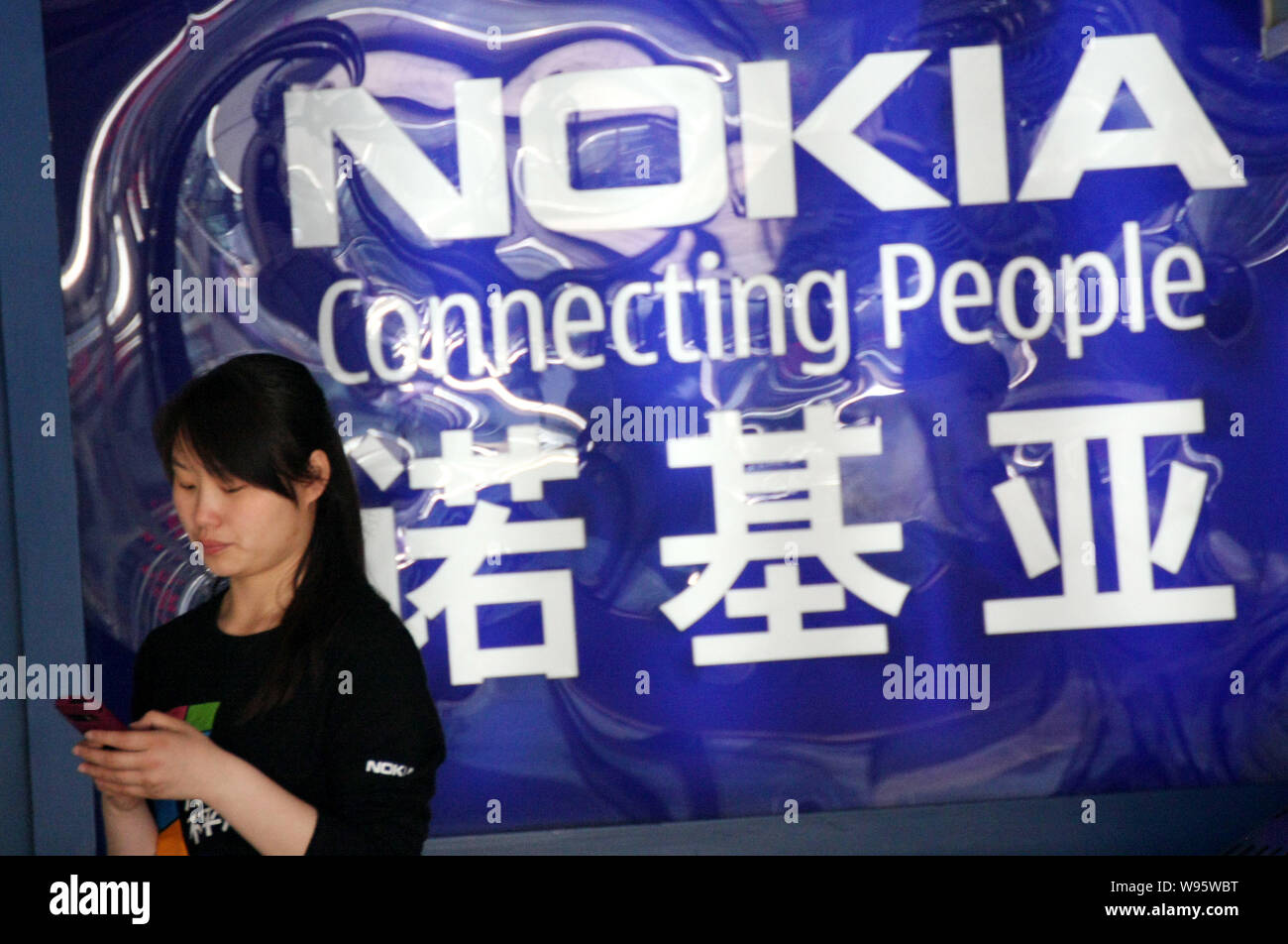 --FILE--A Chinese employee uses her mobile phone at a Nokia store in ...