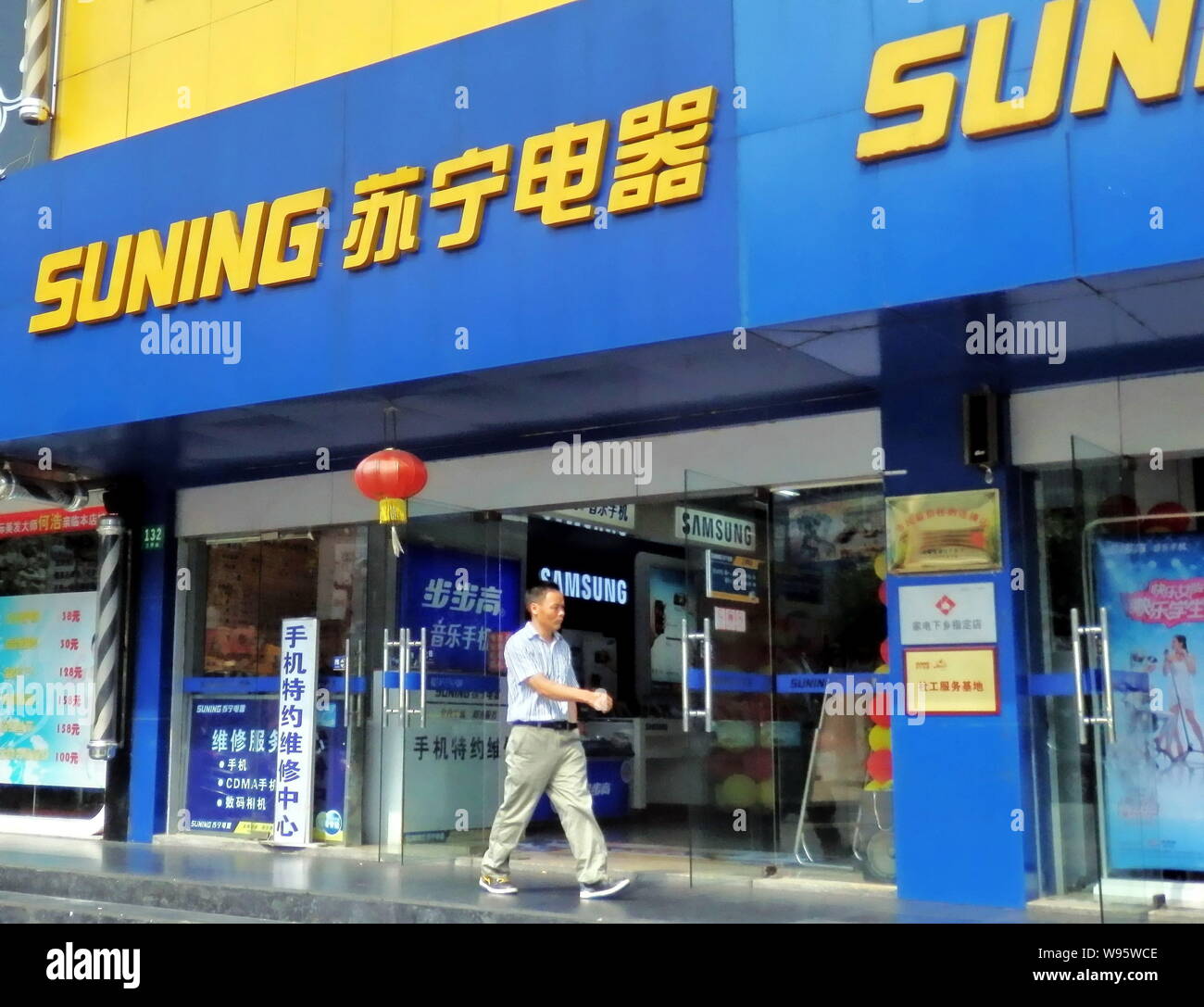 --FILE--A pedestrian walks past a Suning home appliance store in ...