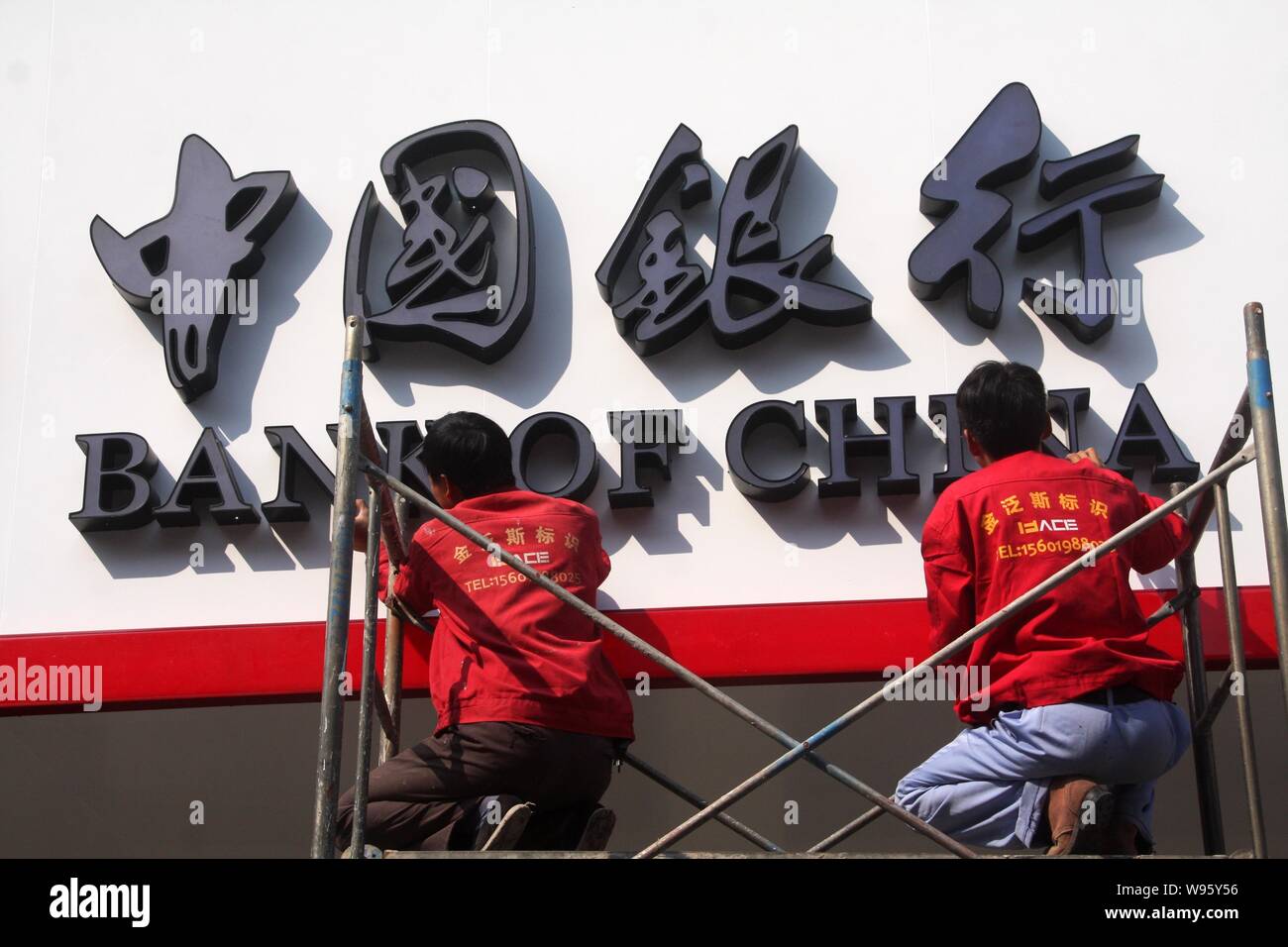 --FILE--Chinese workers install the signage of Bank of China (BOC) at a ...