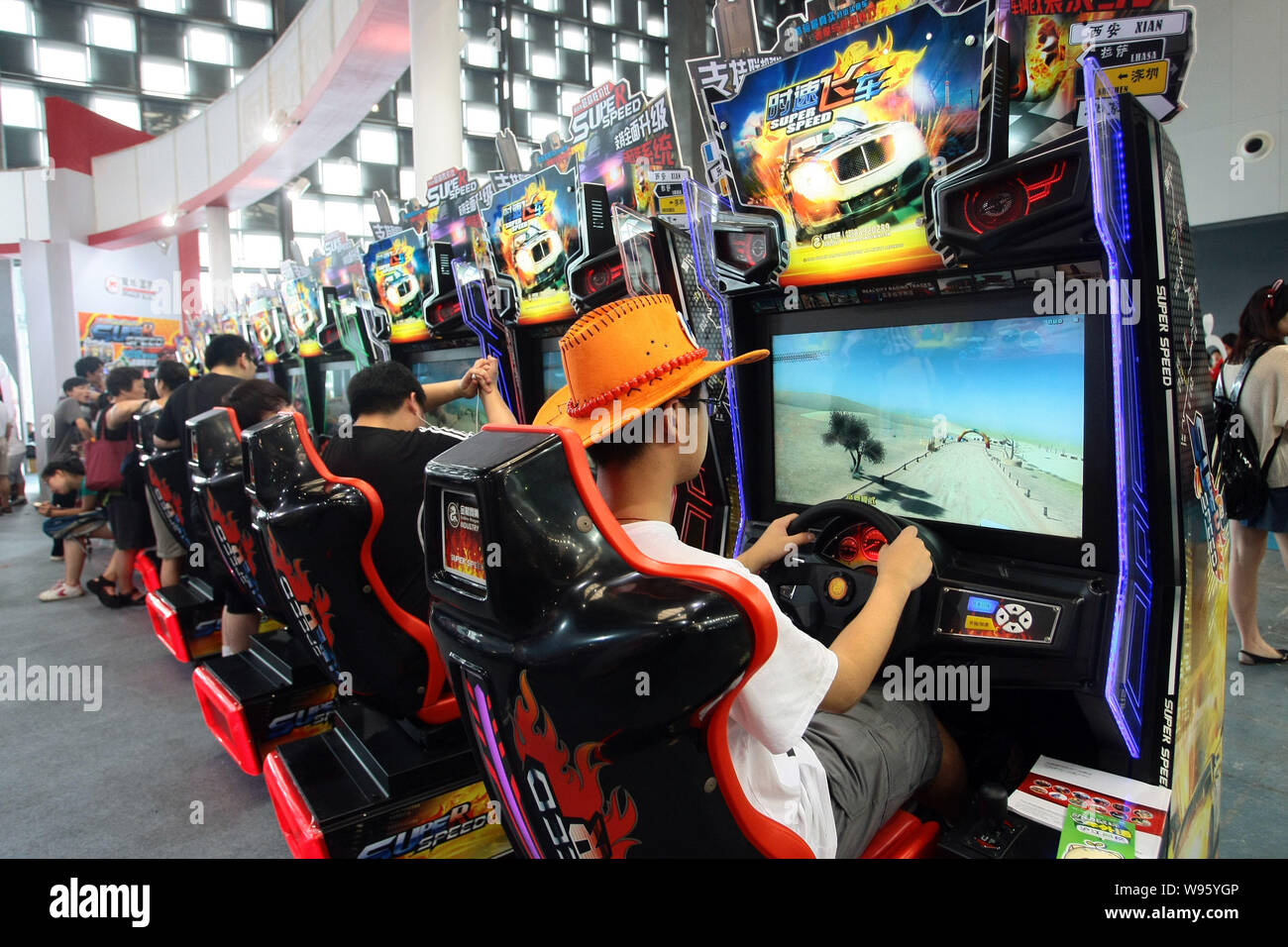 Visitors play electronic racing games during the 8th China ...
