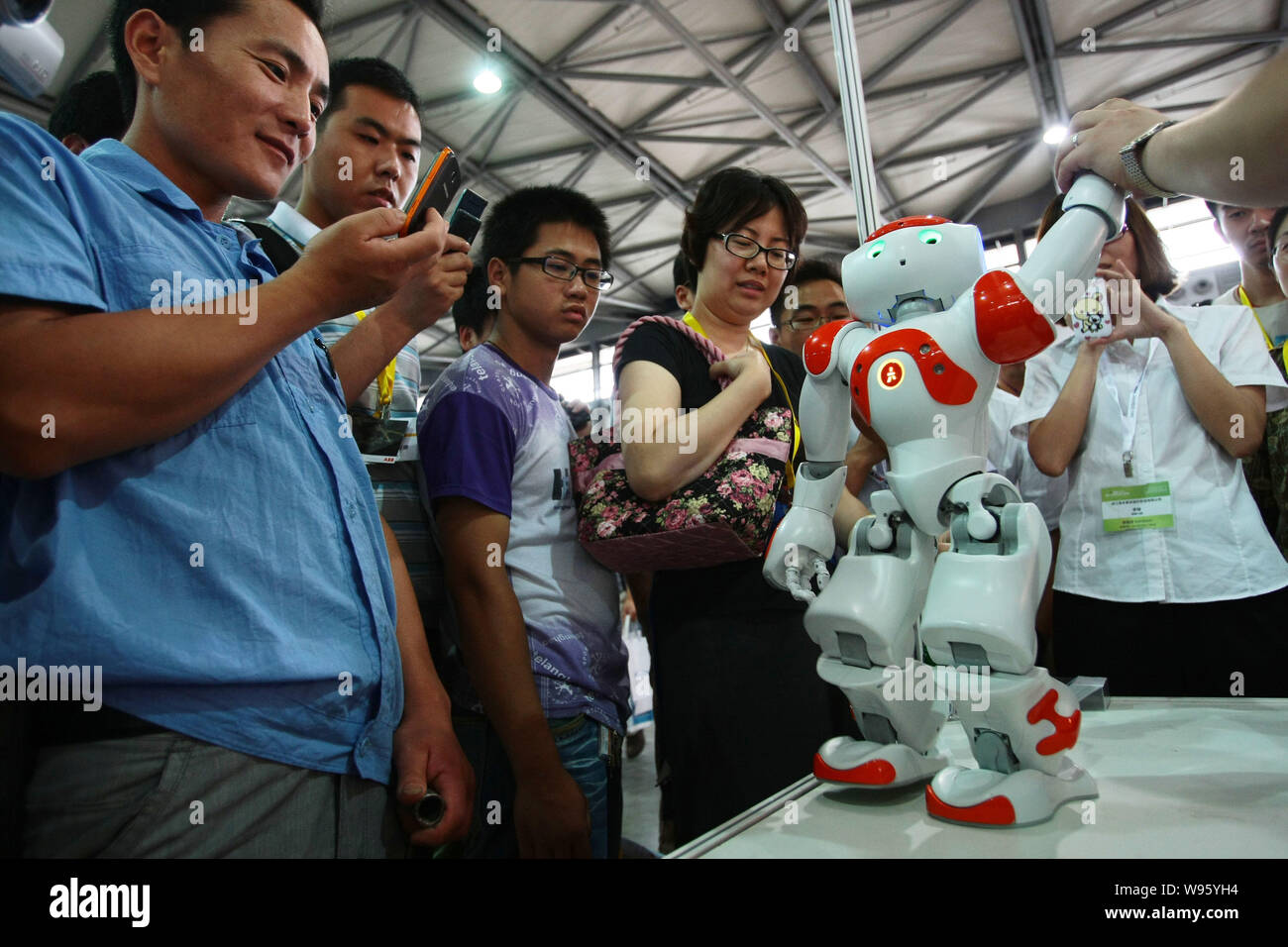 Visitors take pictures of a dancing robot during the China (Shanghai ...